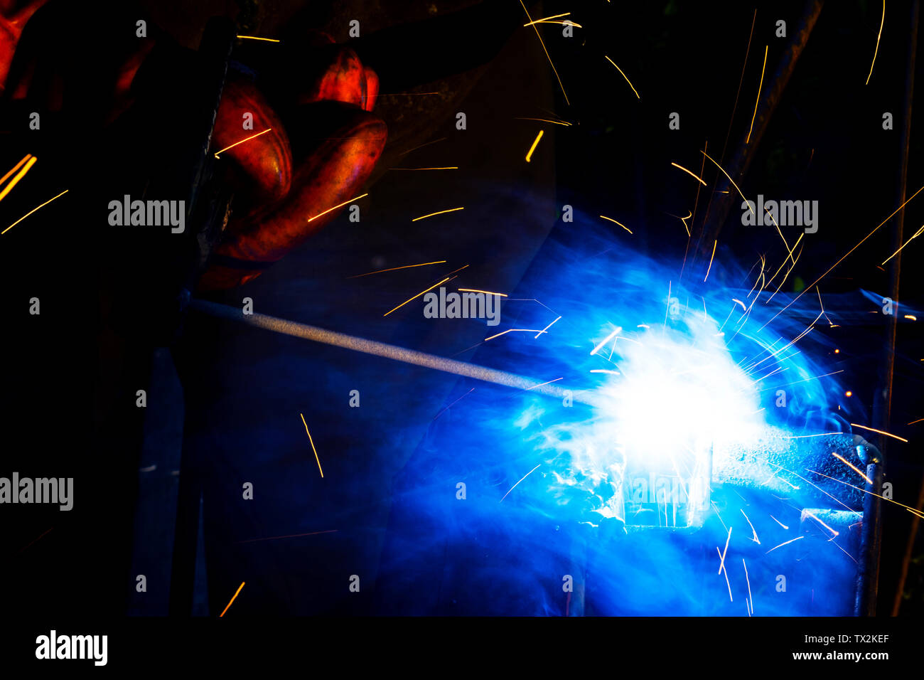 Welder worker performs jump welding. Man welder in protective gloves ...
