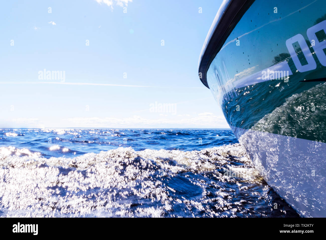 Side view Speeding fishing motor boat with drops of water. Blue ocean ...