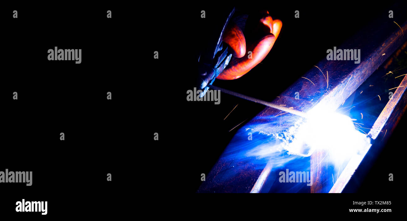 Welder worker performs jump welding. Man welder in protective gloves ...