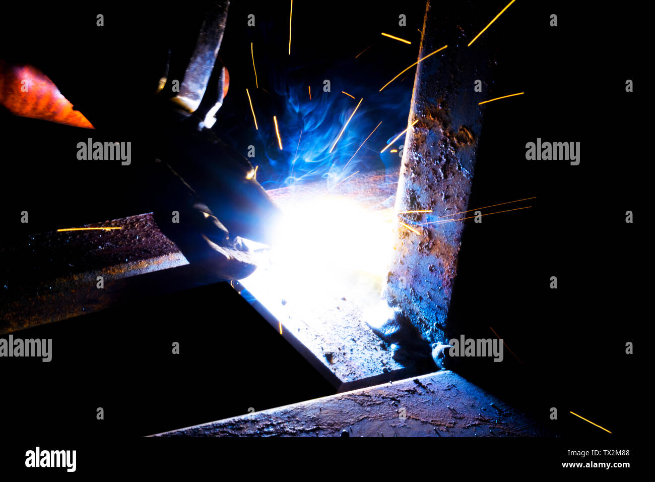 Welder worker performs jump welding. Man welder in protective gloves ...