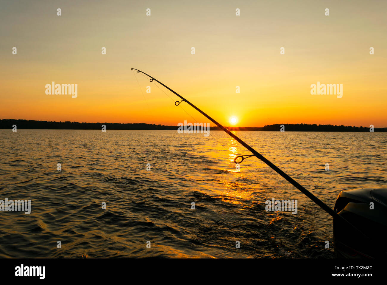 Fishing rod silhouette during sunset. Fishing pole against ocean at ...