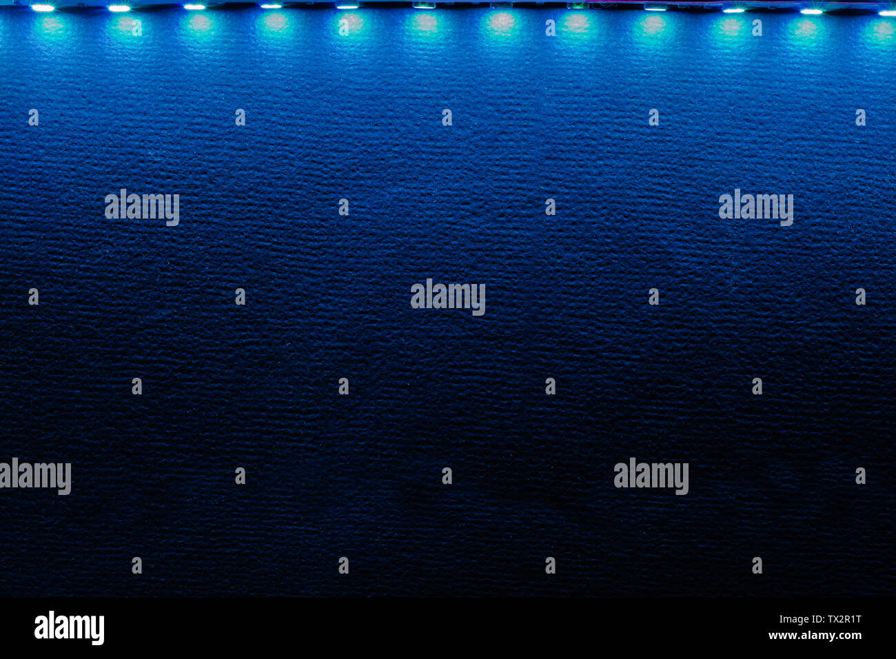 Backlit background of blue led strip lights and reflections on black ...