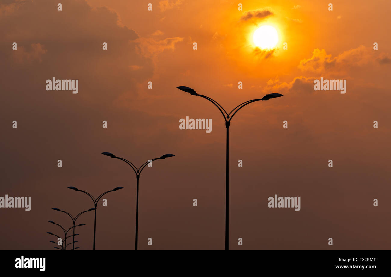 Silhouette street electric pole with beautiful orange and yellow sunset ...