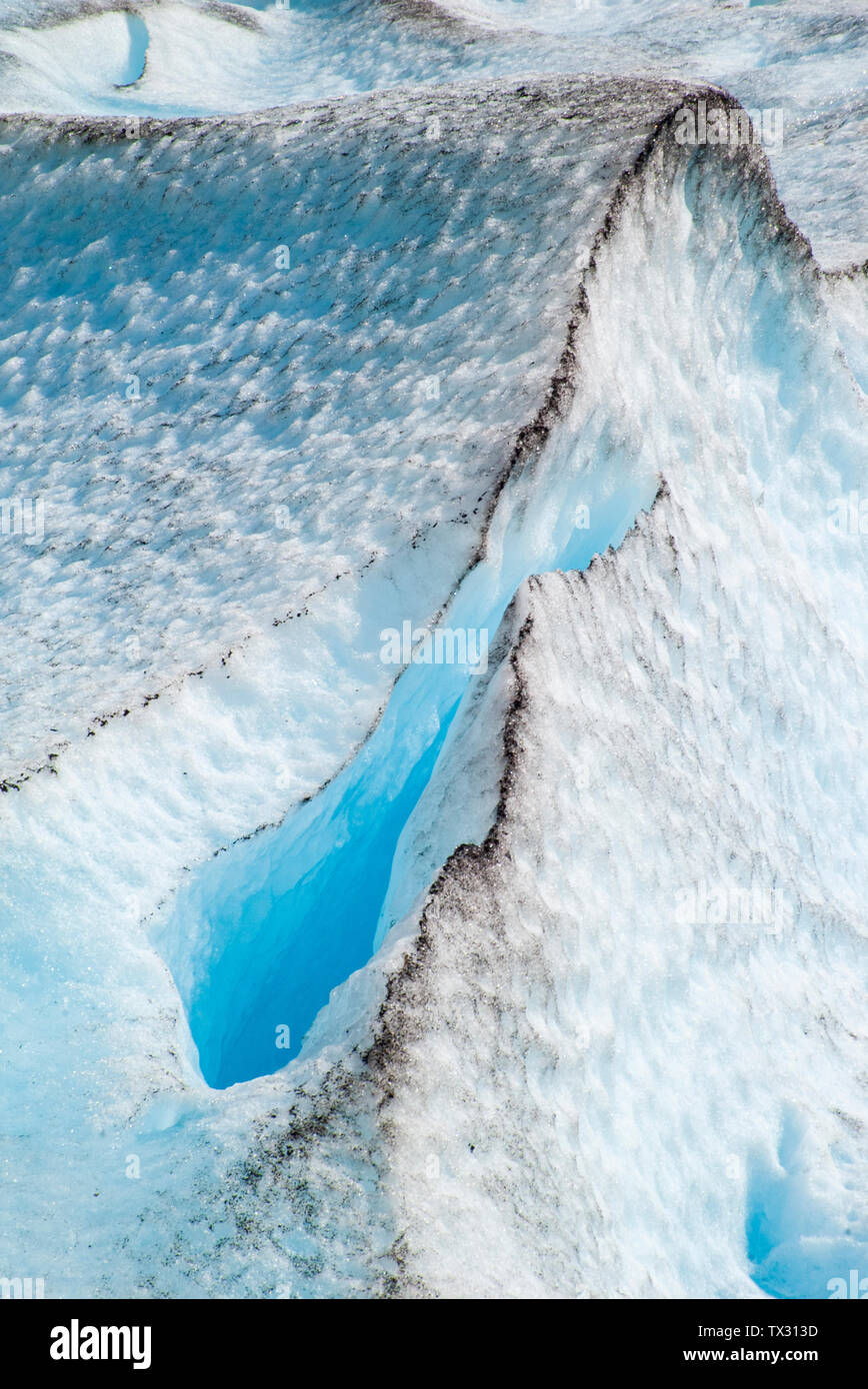 Abstract shapes and lines of glacier ice with dust and sand on the blue ...