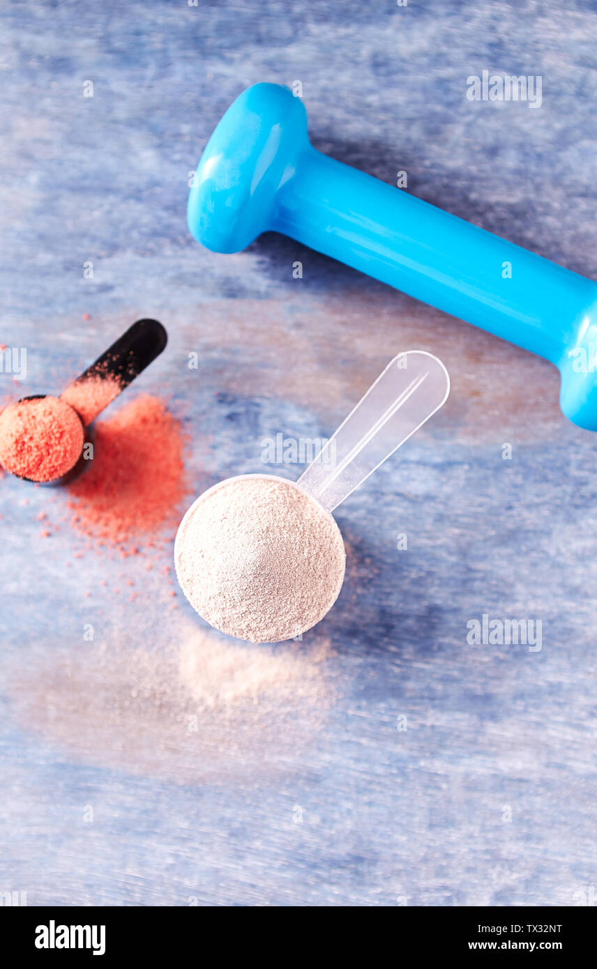 Scoop of Whey Protein, Creatine Powder and a blue Dumbbell in ...