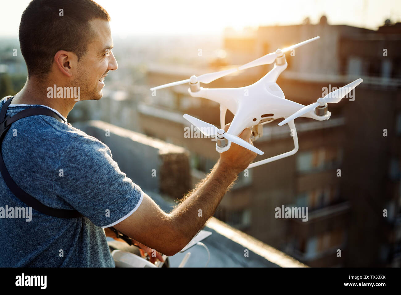 Man operating a drone with remote control on rooftop Stock Photo - Alamy