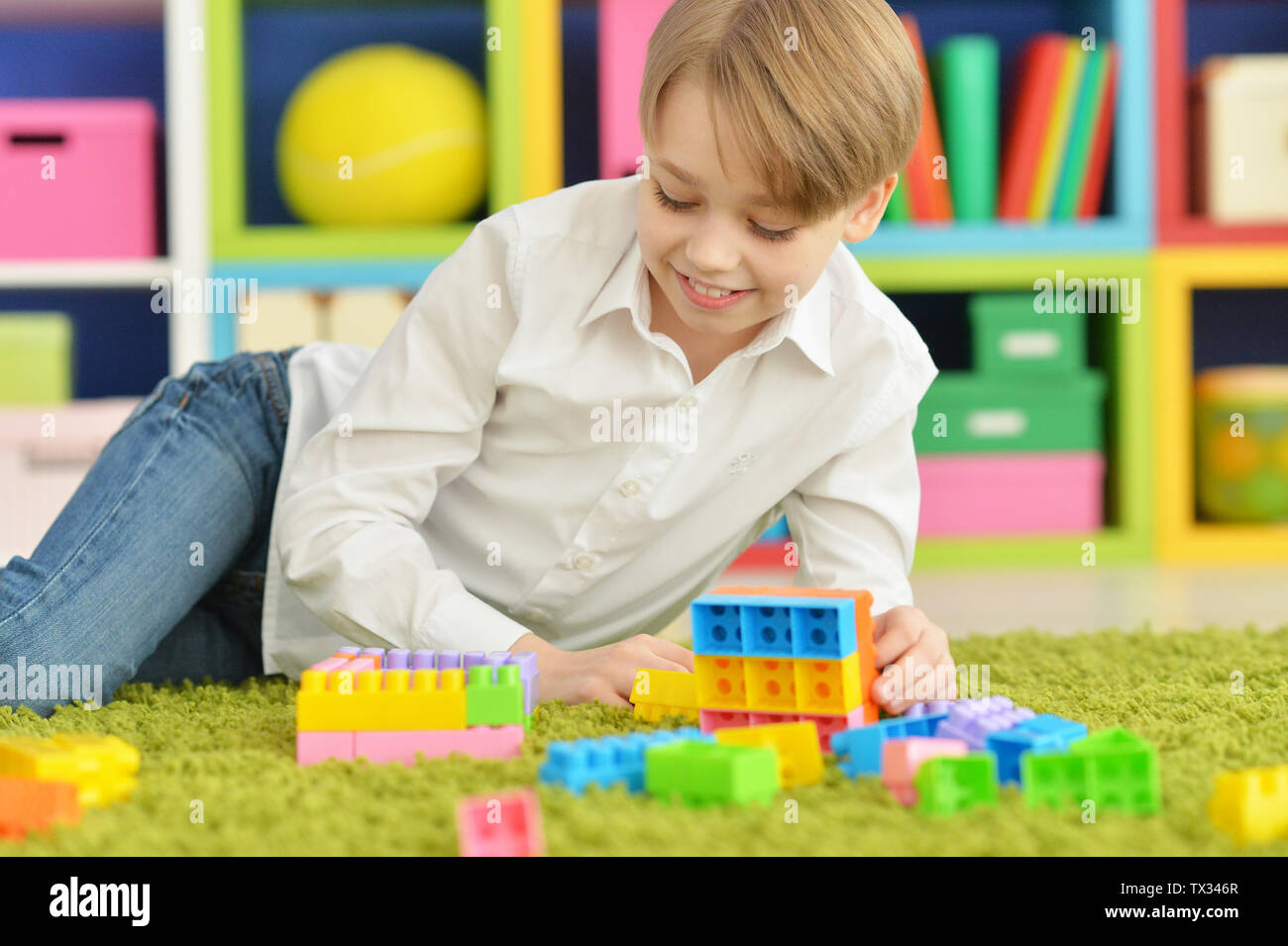 Cute little boy playing with colorful plastic blocks Stock Photo - Alamy