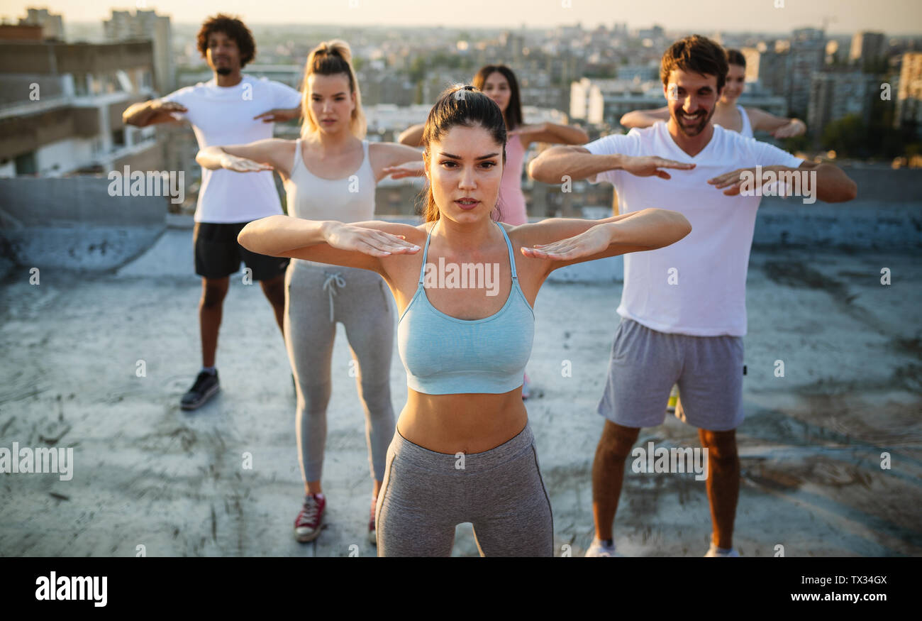 Group of fit healthy friends, people exercising together outdoor on ...