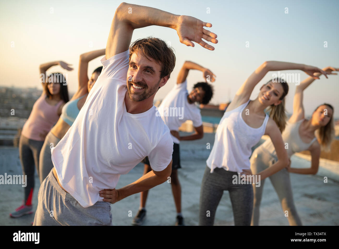 Group of fit healthy friends, people exercising together outdoor on ...