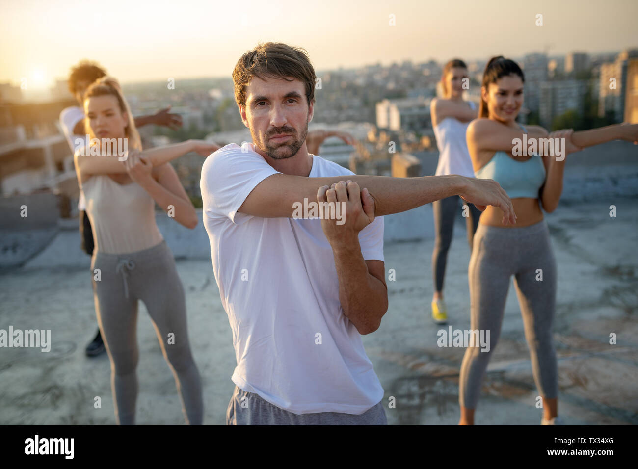 Group of fit healthy friends, people exercising together outdoor on ...