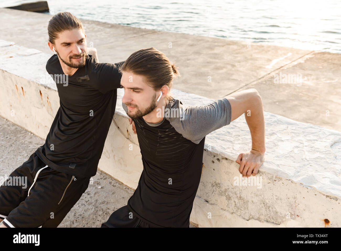 Two attractive twin brothers doing exercises outdoors Stock Photo - Alamy
