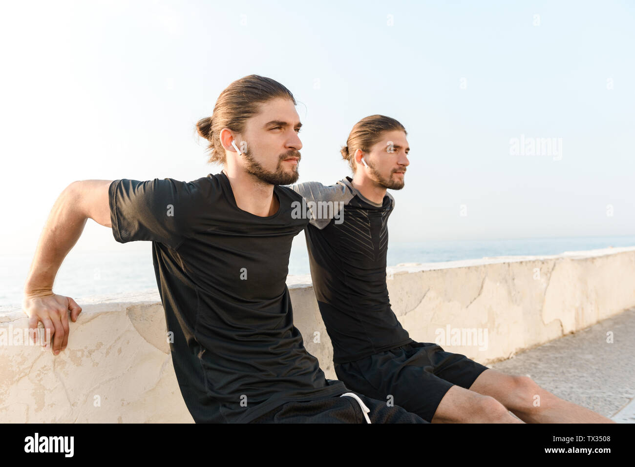 Two attractive twin brothers doing exercises outdoors Stock Photo - Alamy