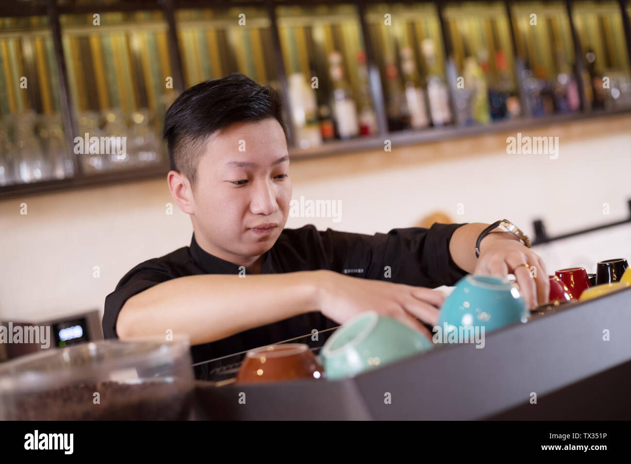 Young waiter serving coffee hi-res stock photography and images - Alamy