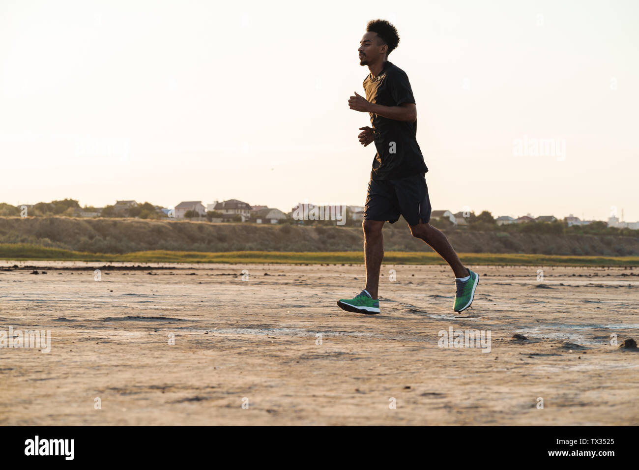 Picture of a handsome young african strong sports man running outdoors ...
