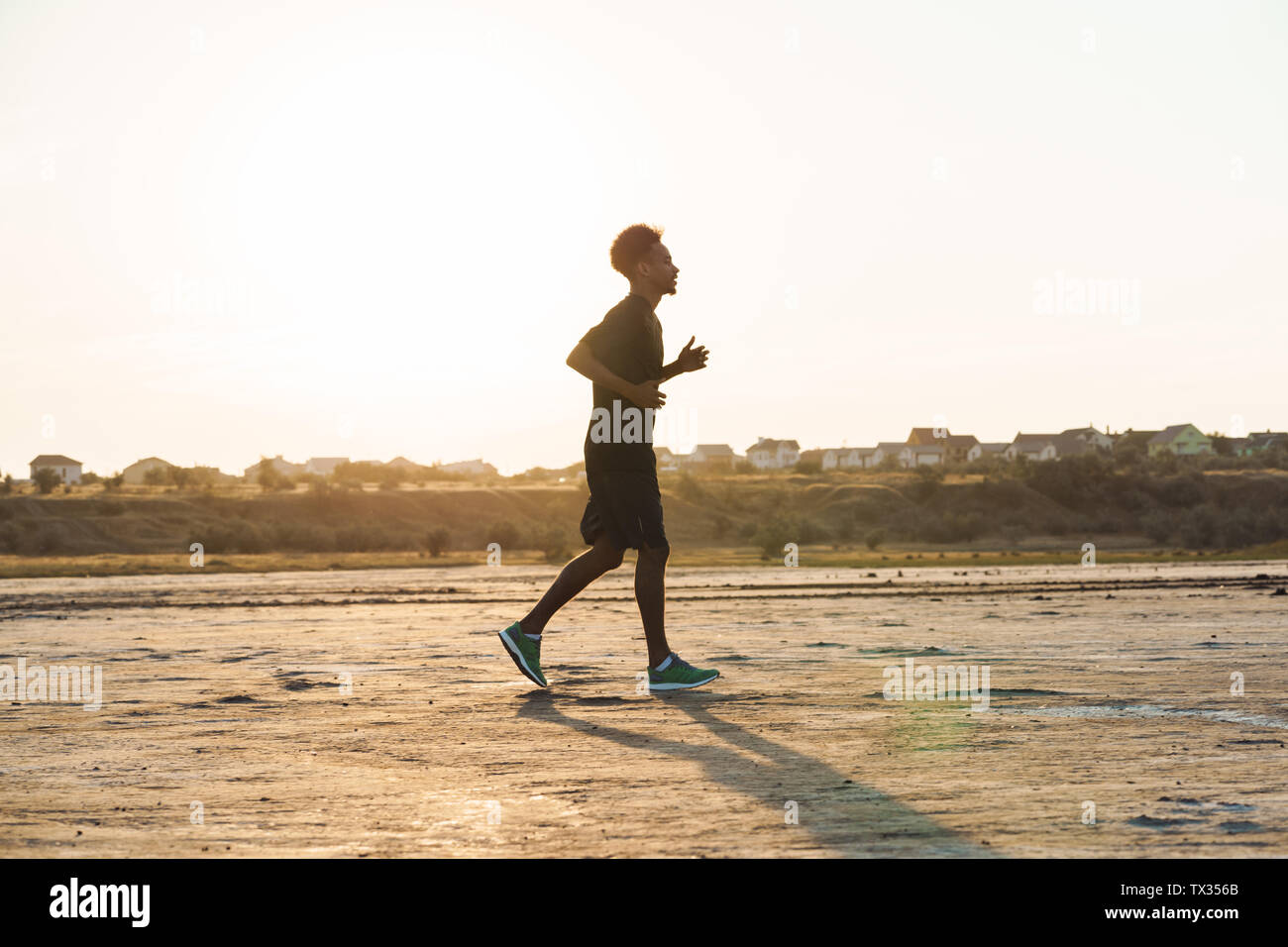 Picture of a handsome young african strong sports man running outdoors ...