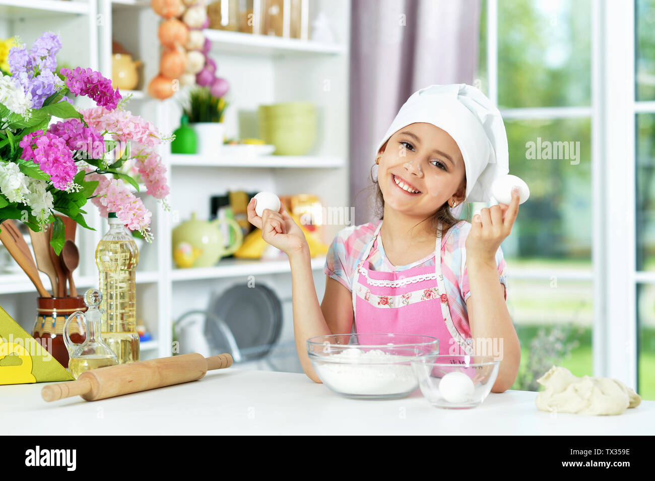 Cute girl making dough in the kitchen Stock Photo - Alamy
