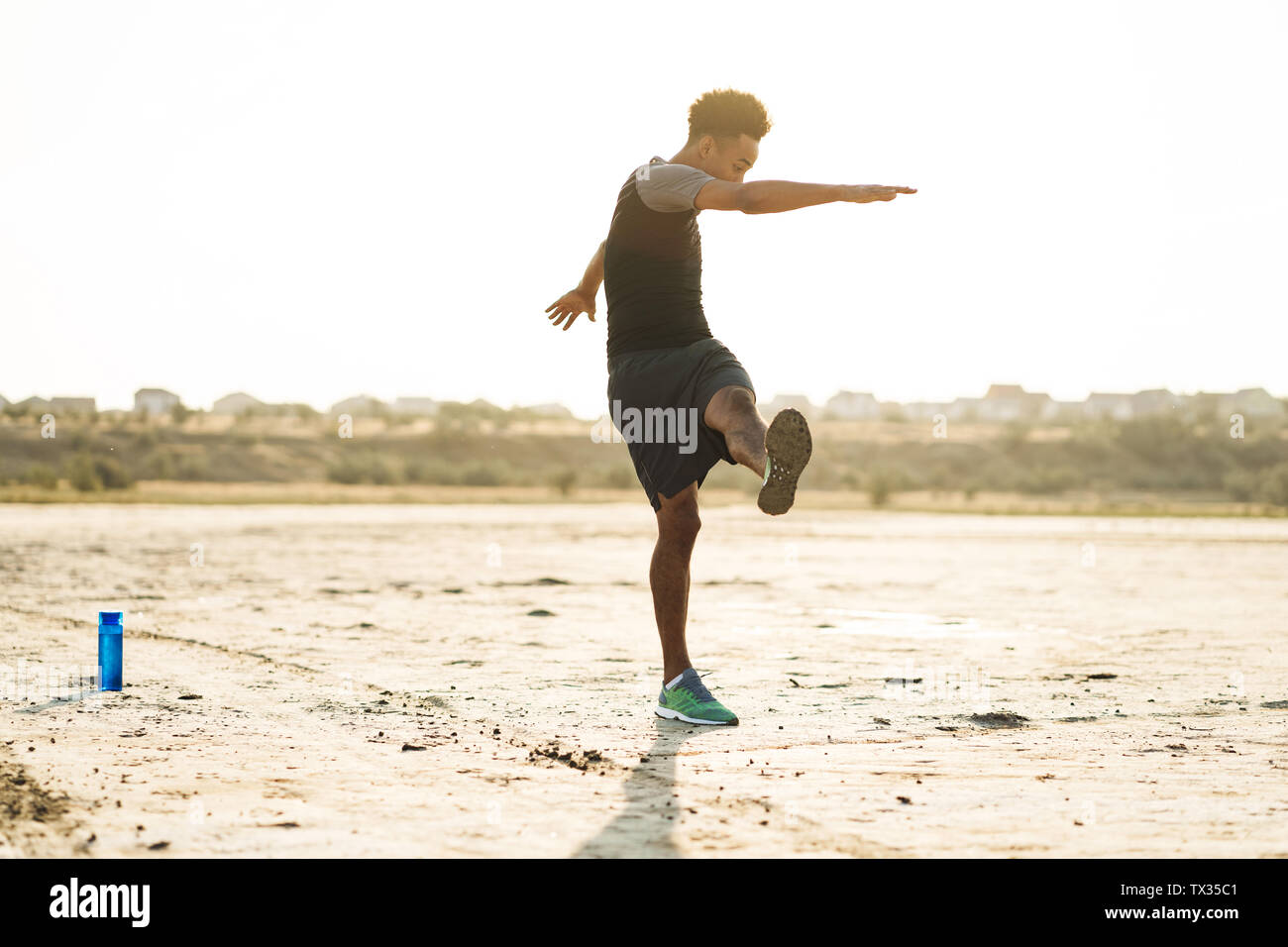 Image of a handsome young sports man make fitness exercises outdoors ...