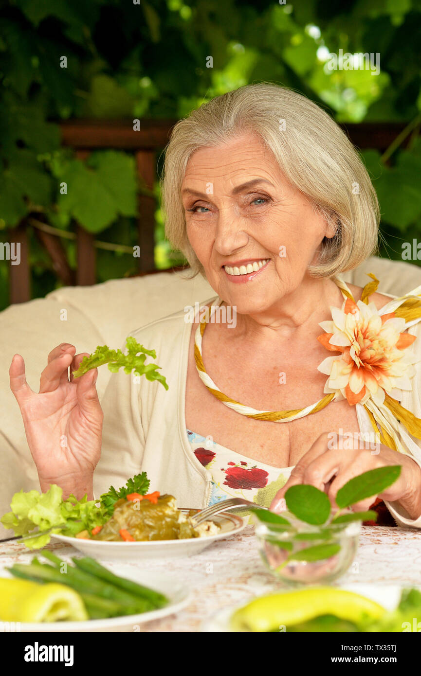 Smiling beautiful senior woman eating healthy breakfast Stock Photo - Alamy