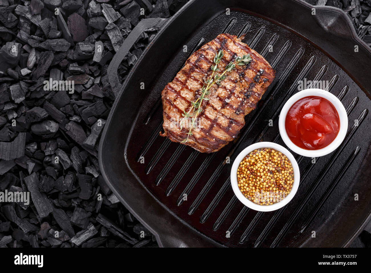 Grilled steak cooked in a frying pan. Background of coals for cooking ...