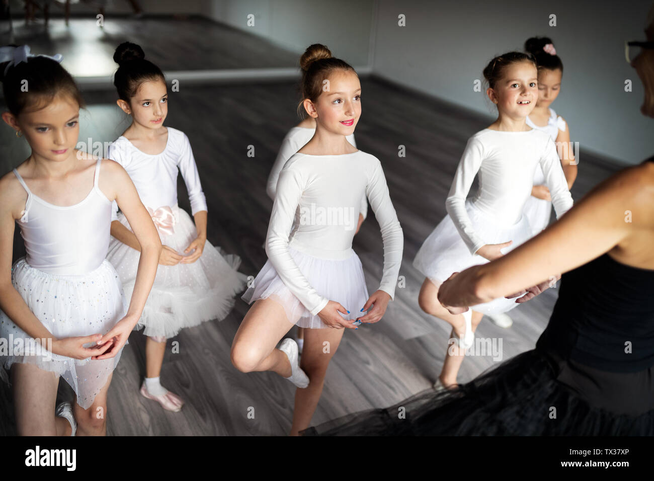 Group of fit happy children exercising ballet in studio together Stock ...