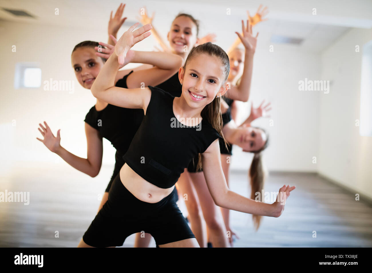 Group of fit happy children exercising ballet in studio together Stock ...