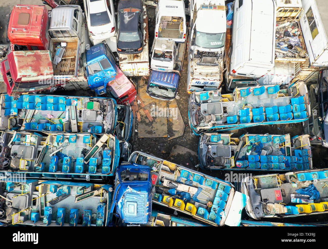 Piled together, scrap-out old motor vehicles waiting to be dismantled ...