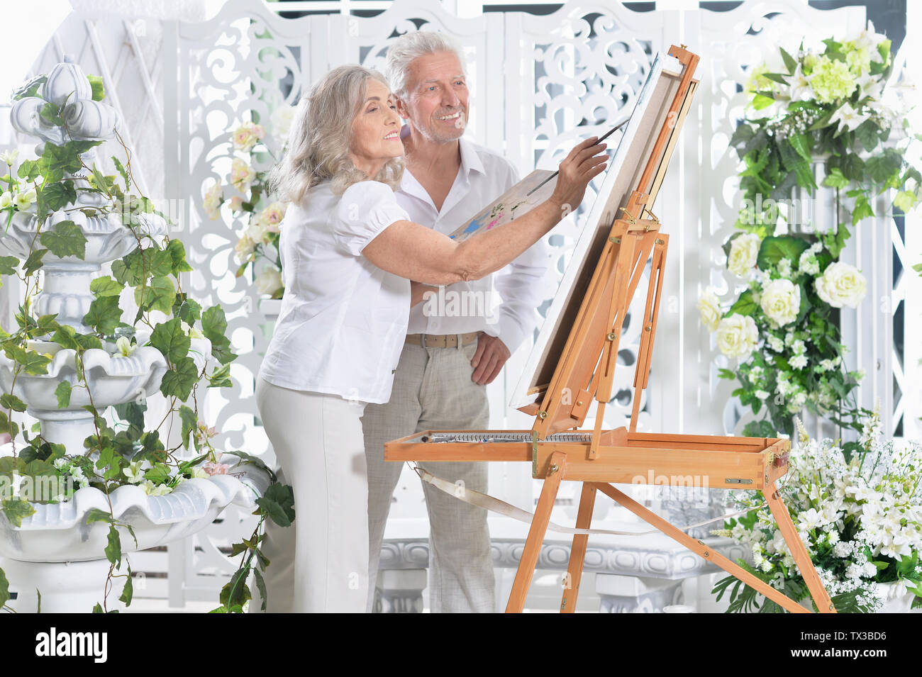 Portrait of cute elderly couple painting at home Stock Photo - Alamy
