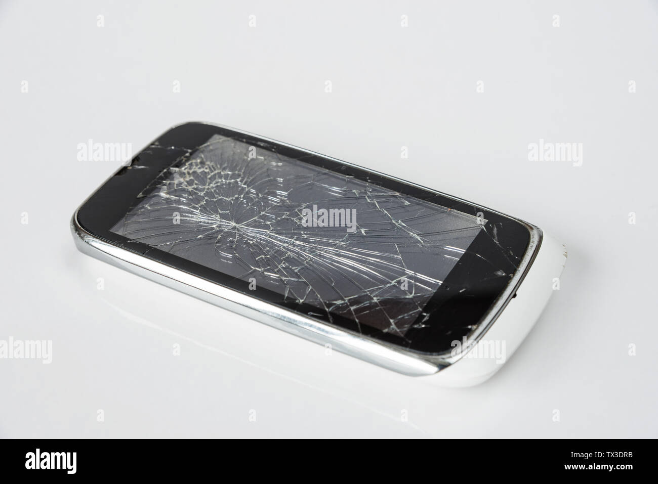 Smartphone with a broken screen closeup on white background. Phone ...