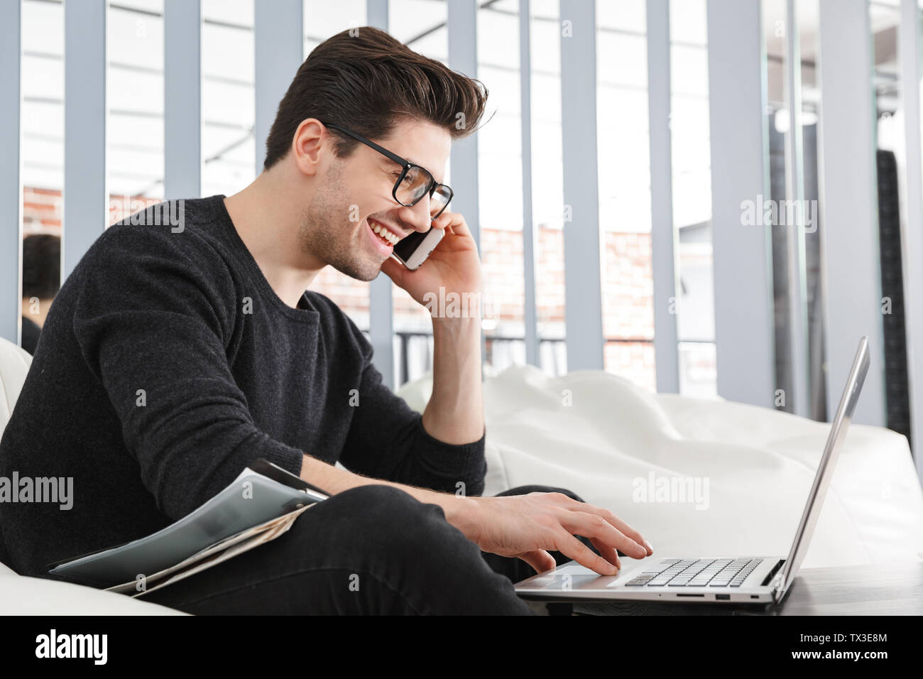 Image of a happy handsome young man at home indoors using laptop ...