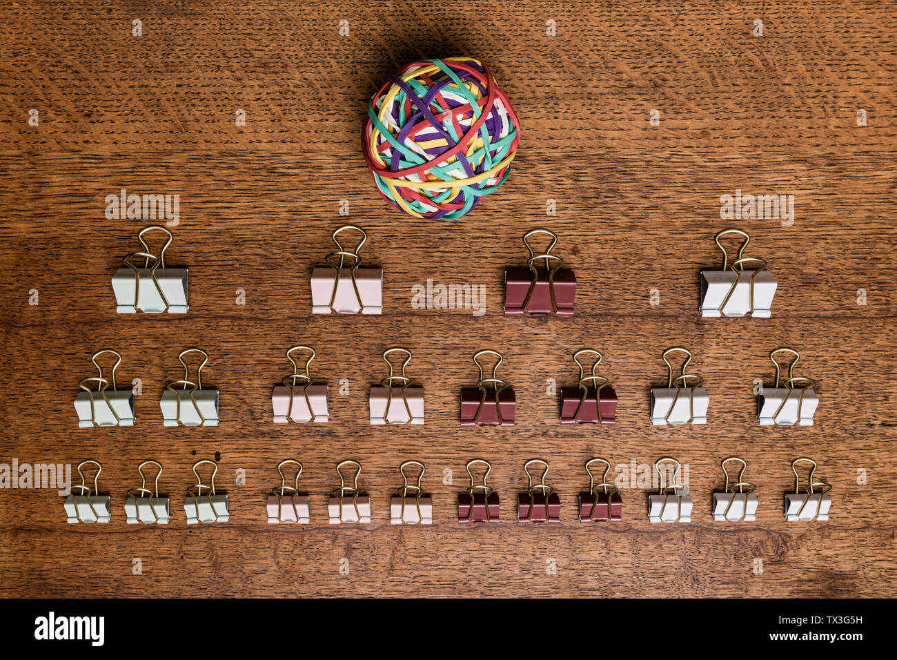 View from above binder clips and rubber band ball on wooden desk ...