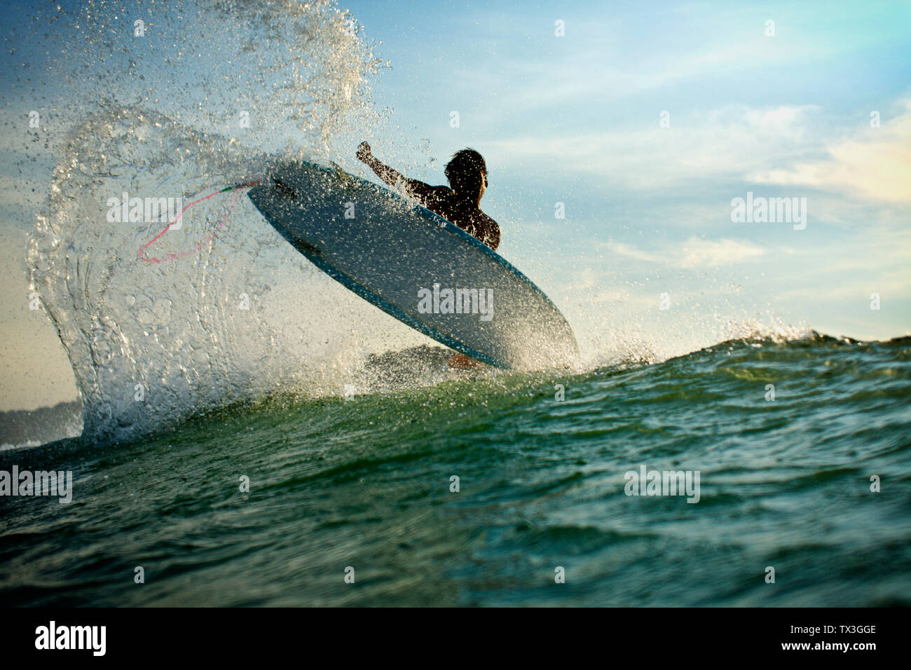 Surfer catching air behind wave on ocean, Sayulita, Nayarit, Mexico ...