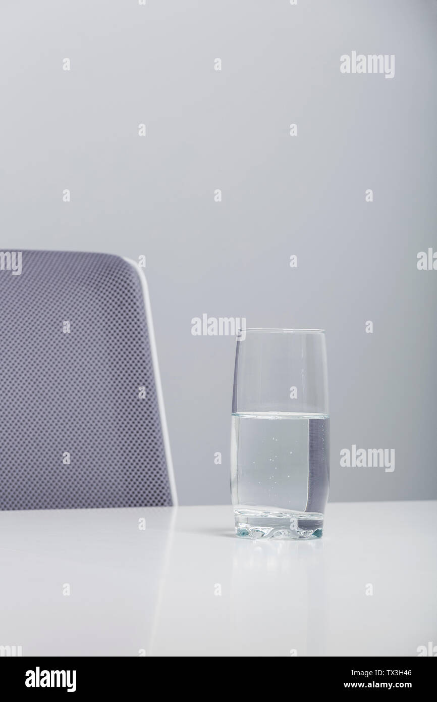 Glass of water on conference room table Stock Photo - Alamy