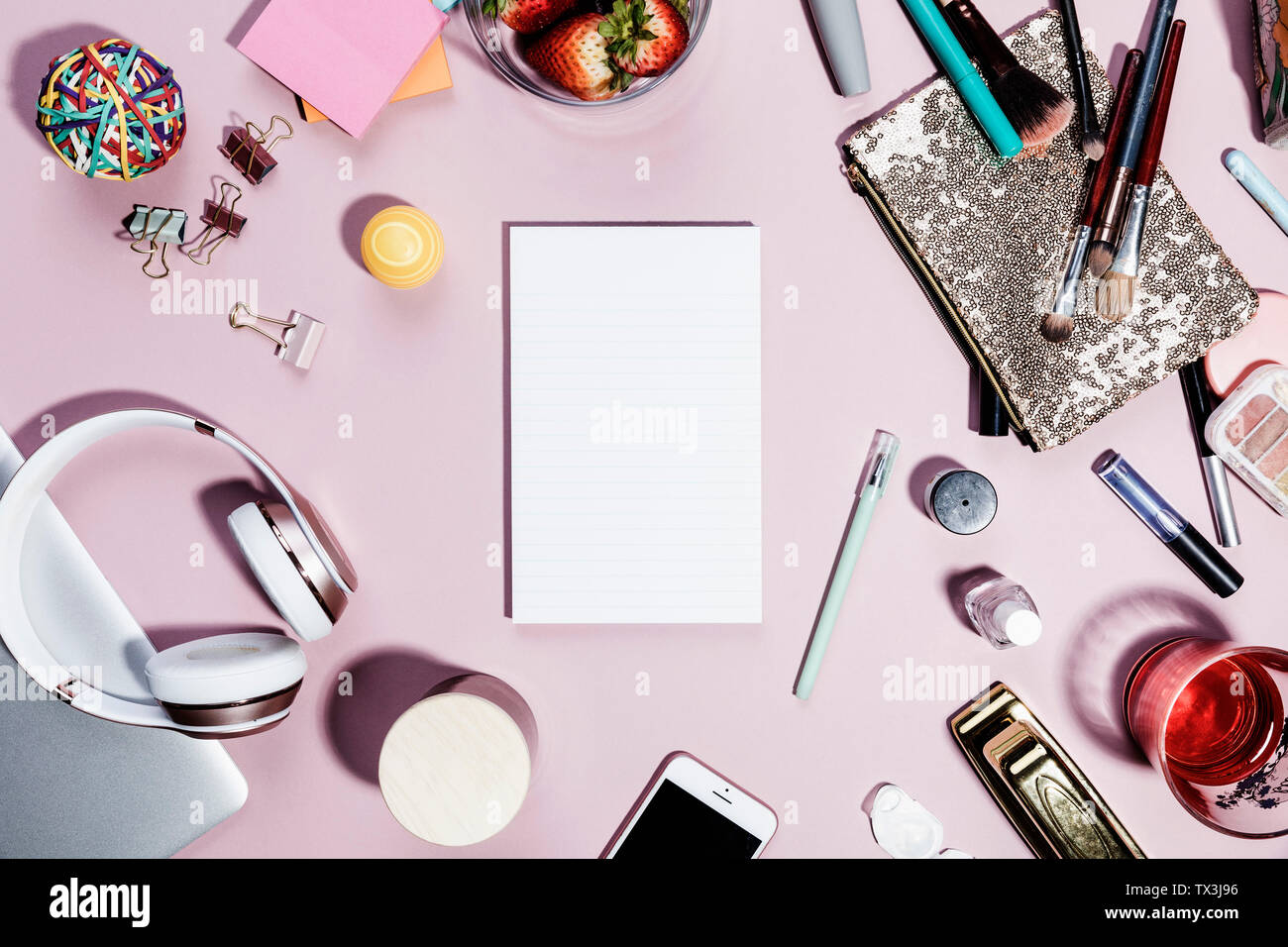 View form above blank notepad surrounded by personal belongings on pink ...