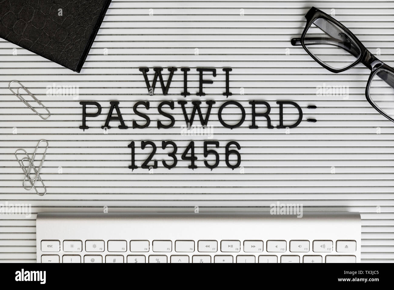 View form above "Wifi Password 123456" on desk above computer keyboard ...