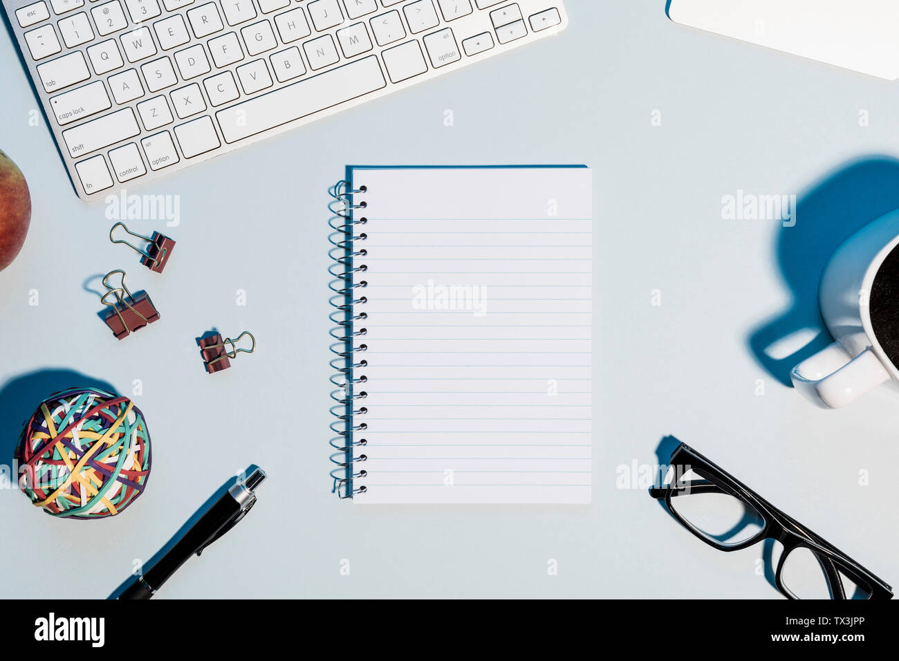 View form above blank, lined notebook on desk below computer keyboard ...