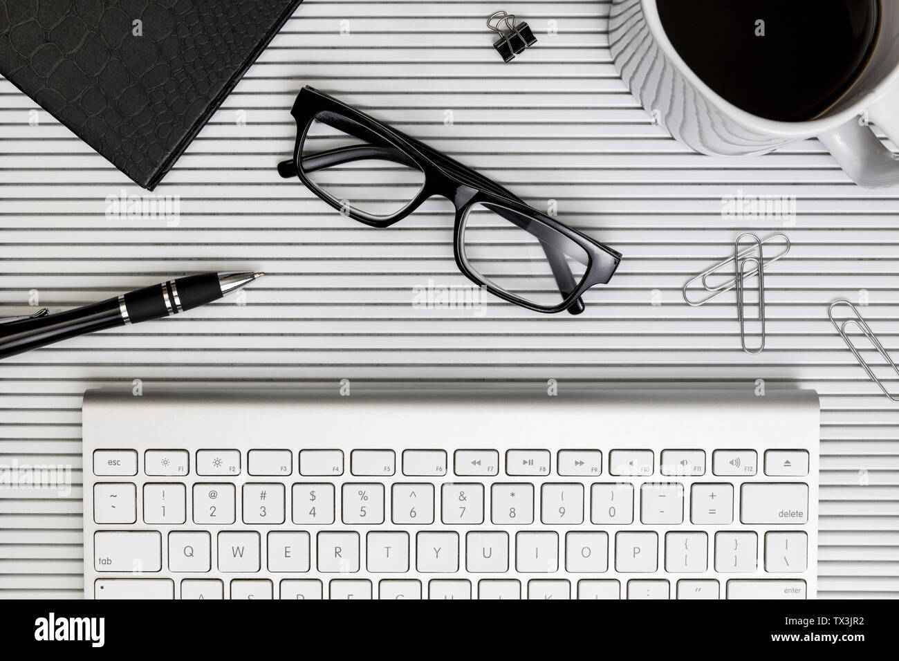 View form above eyeglasses, coffee, pen and paper clips on desk above ...