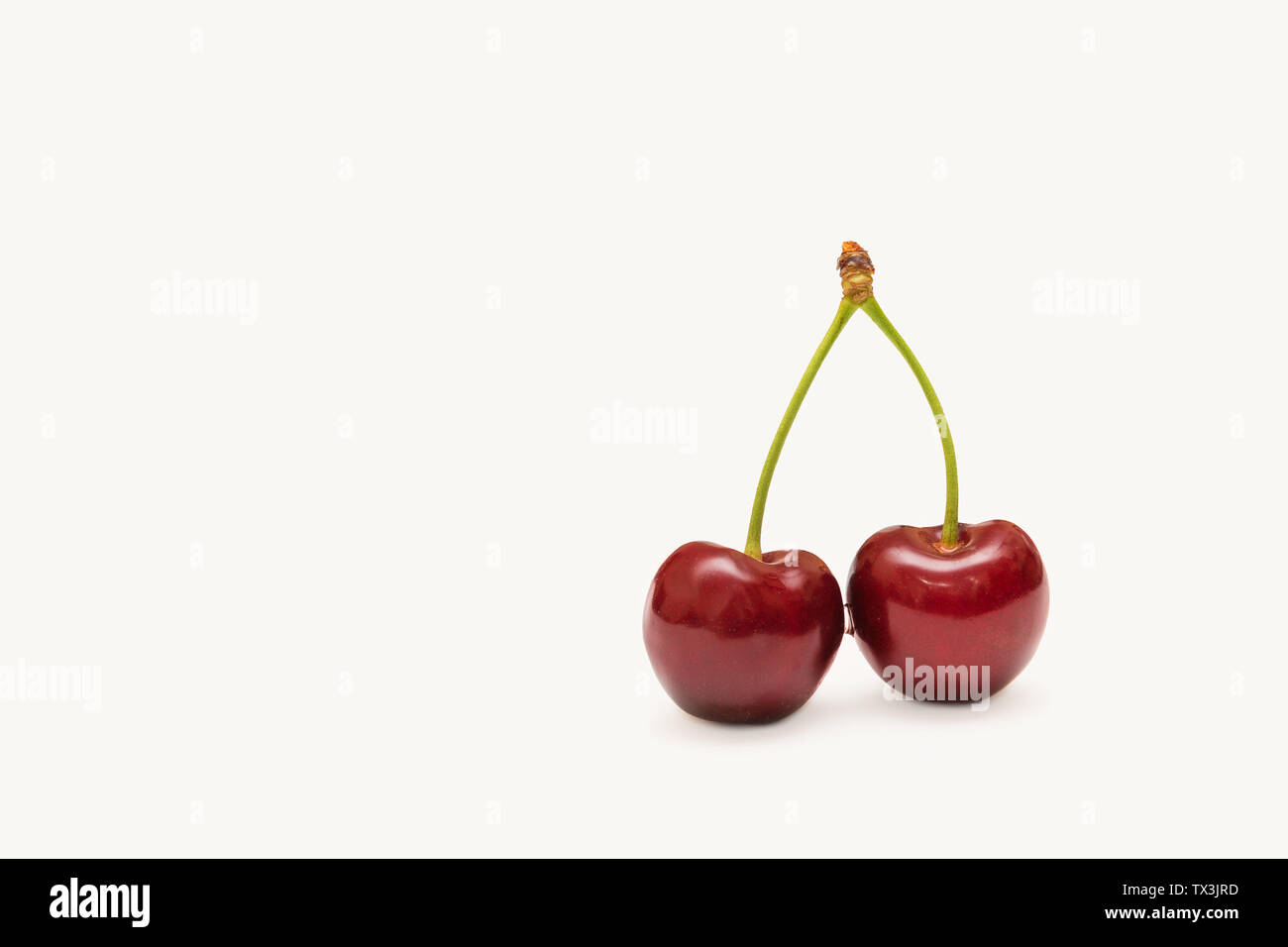 Two red cherries isolated on white background Stock Photo - Alamy