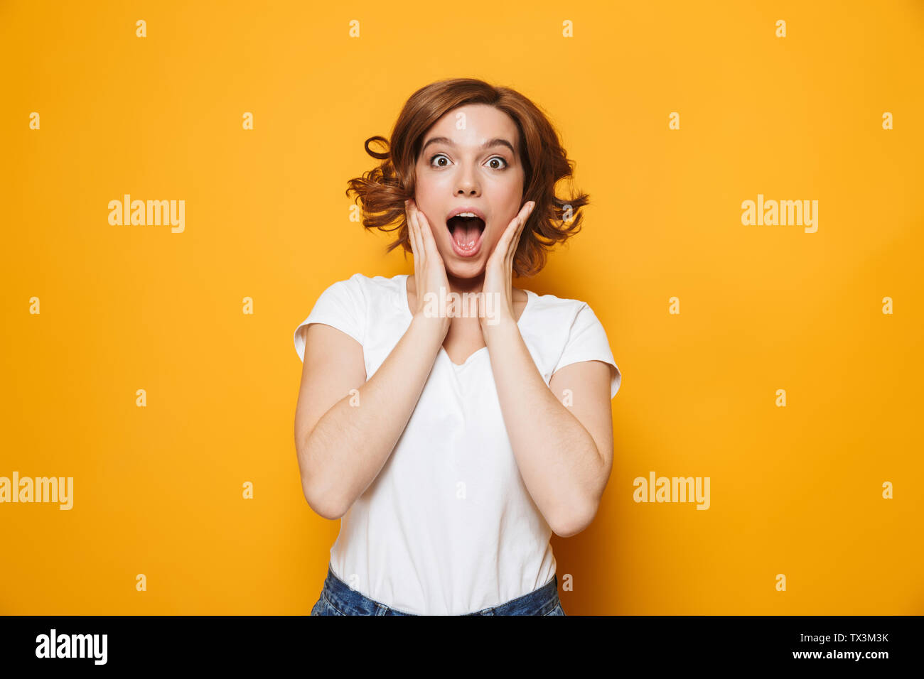 Cheerful young girl wearing t-shirt standing isolated over yellow ...