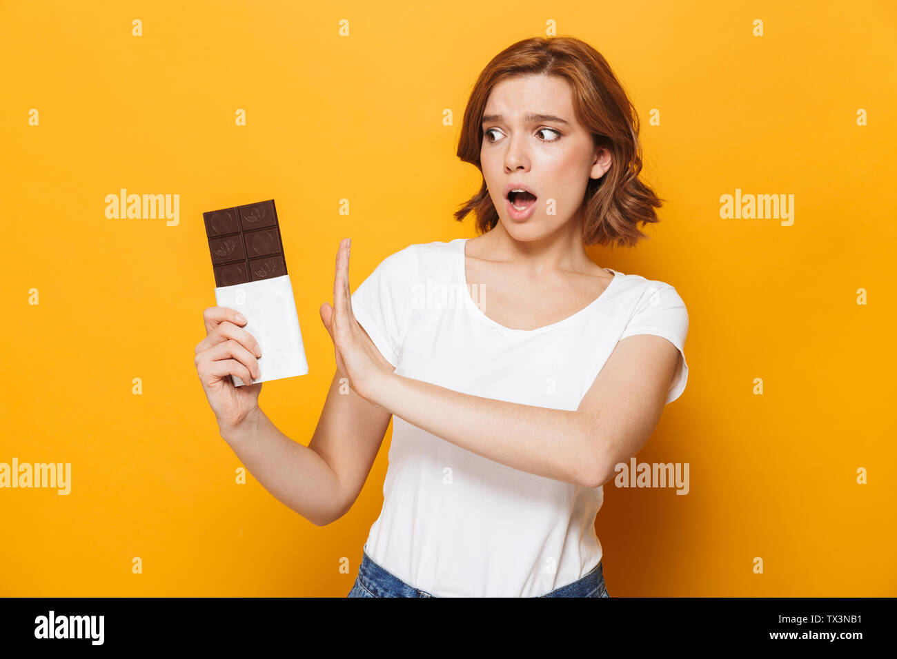 Portrait of a indecisive lovely girl standing isolated over yellow ...