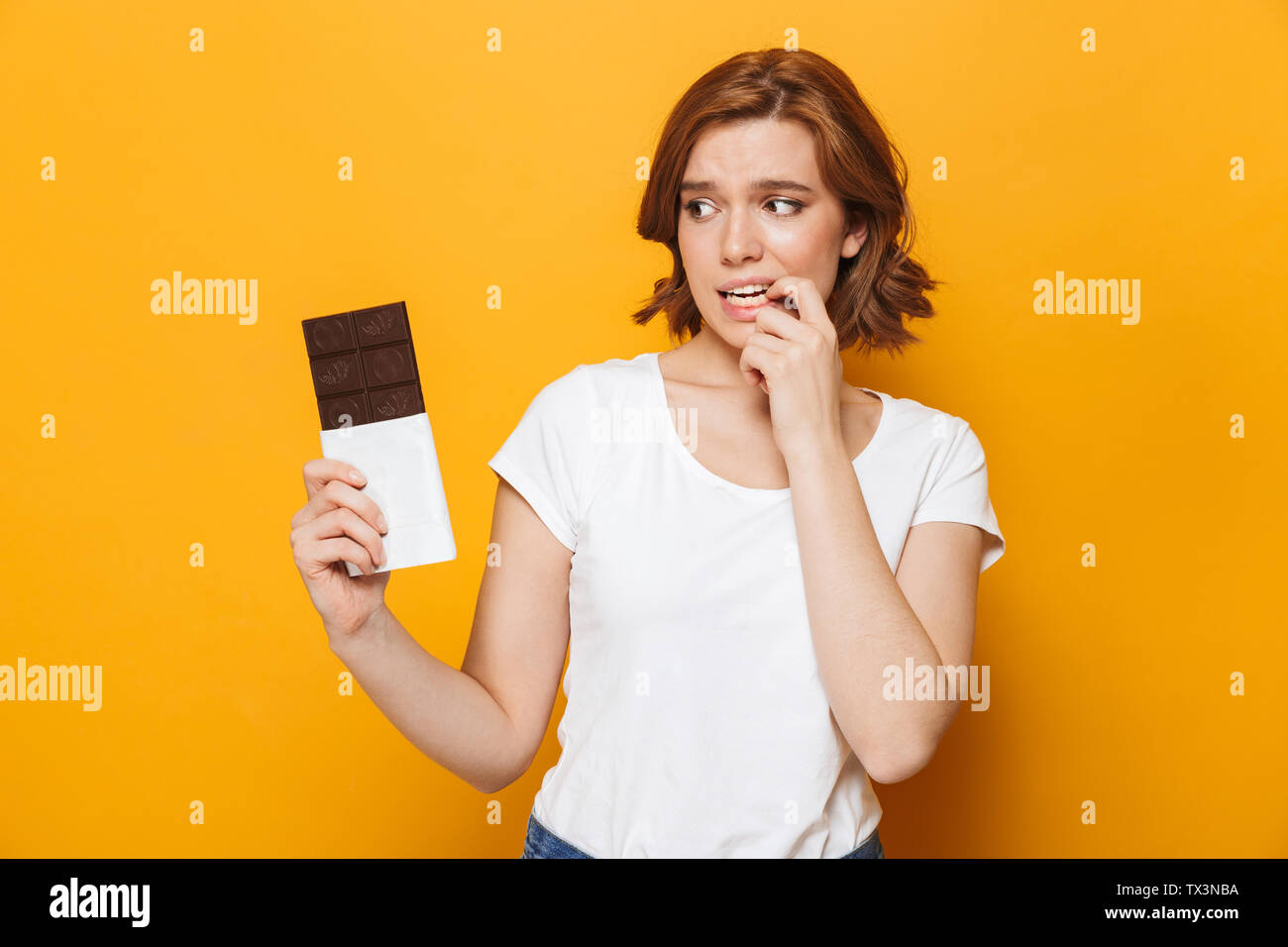 Portrait of a indecisive lovely girl standing isolated over yellow ...