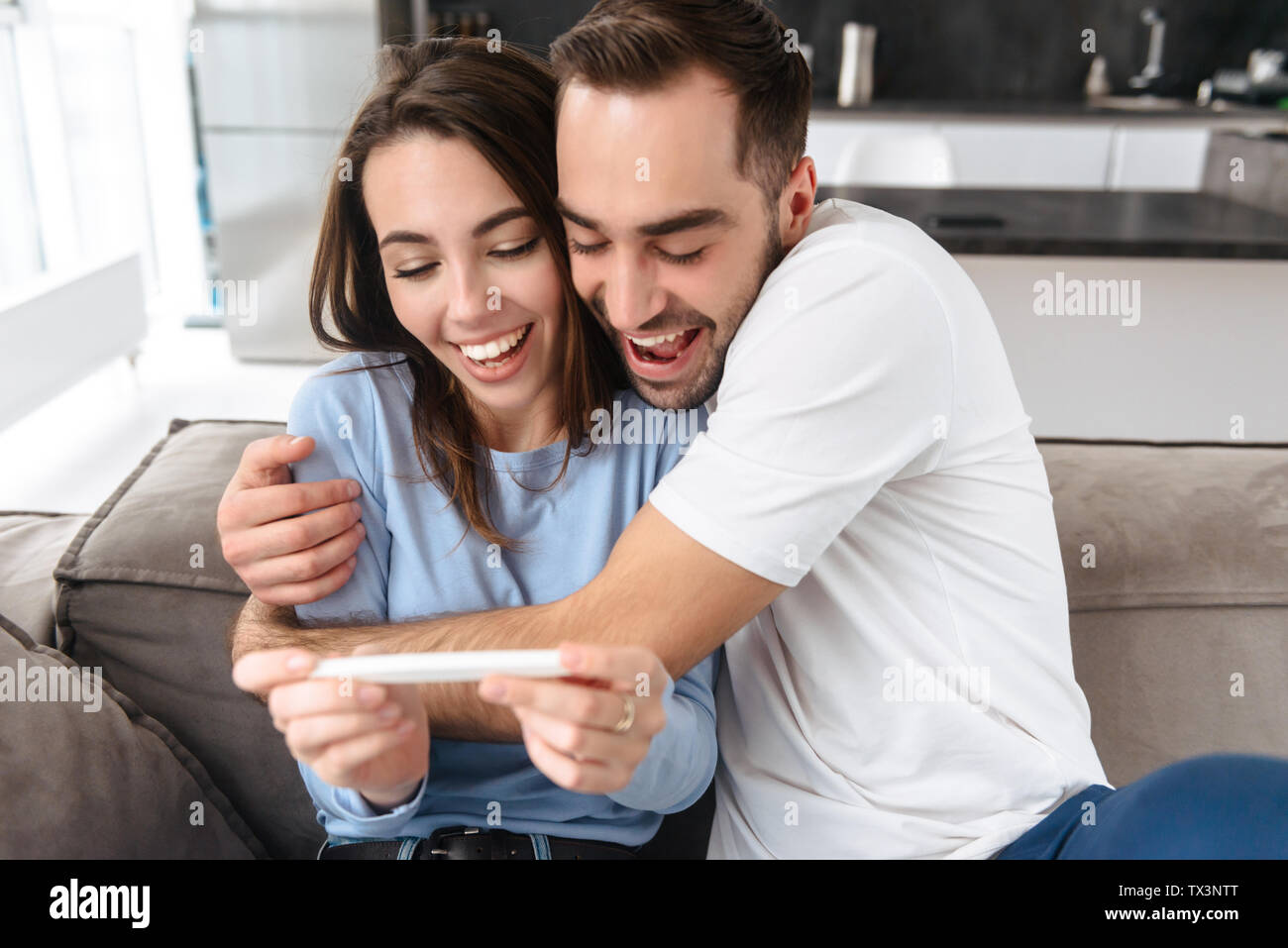 Lovely young couple holdingpregnancy test, celebrating Stock Photo - Alamy