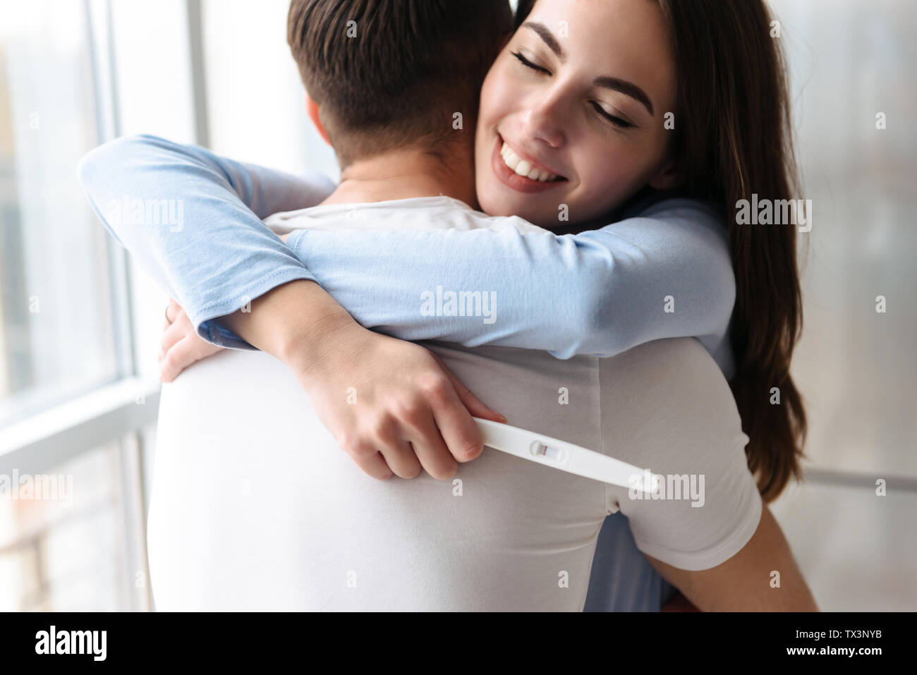 Lovely young couple holdingpregnancy test, celebrating Stock Photo - Alamy