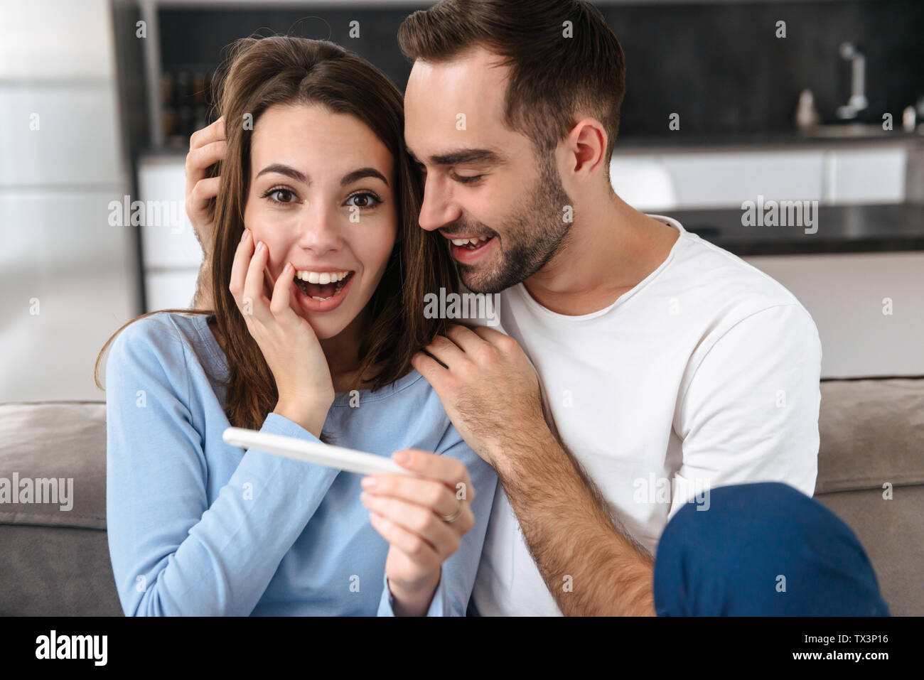 Lovely young couple holdingpregnancy test, celebrating Stock Photo - Alamy
