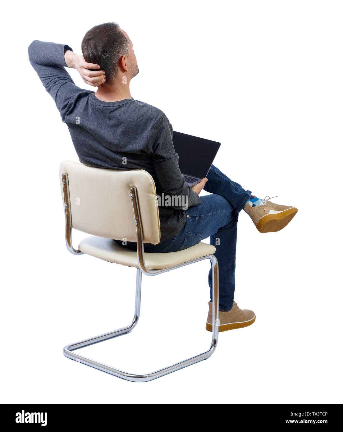Back view of a man who sits on a chair with a laptop. Rear view people ...