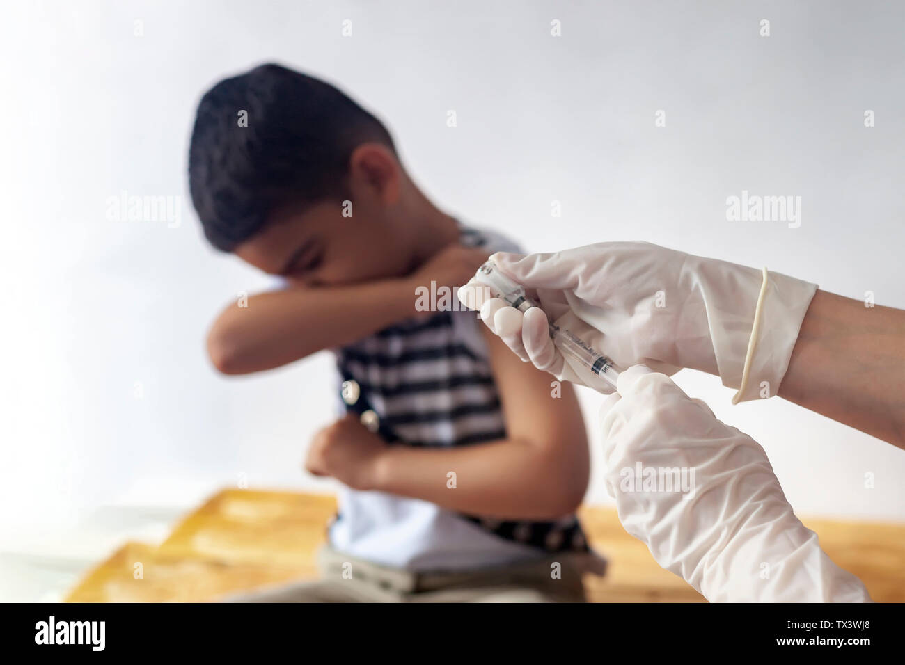 A doctor vaccinating young patient. Little boy scared of injection ...