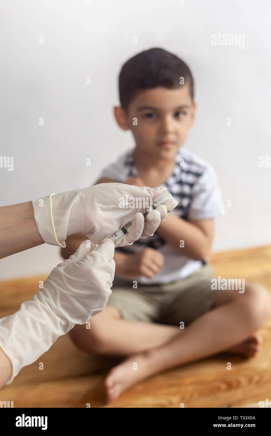 A doctor vaccinating young patient. Little boy scared of injection ...