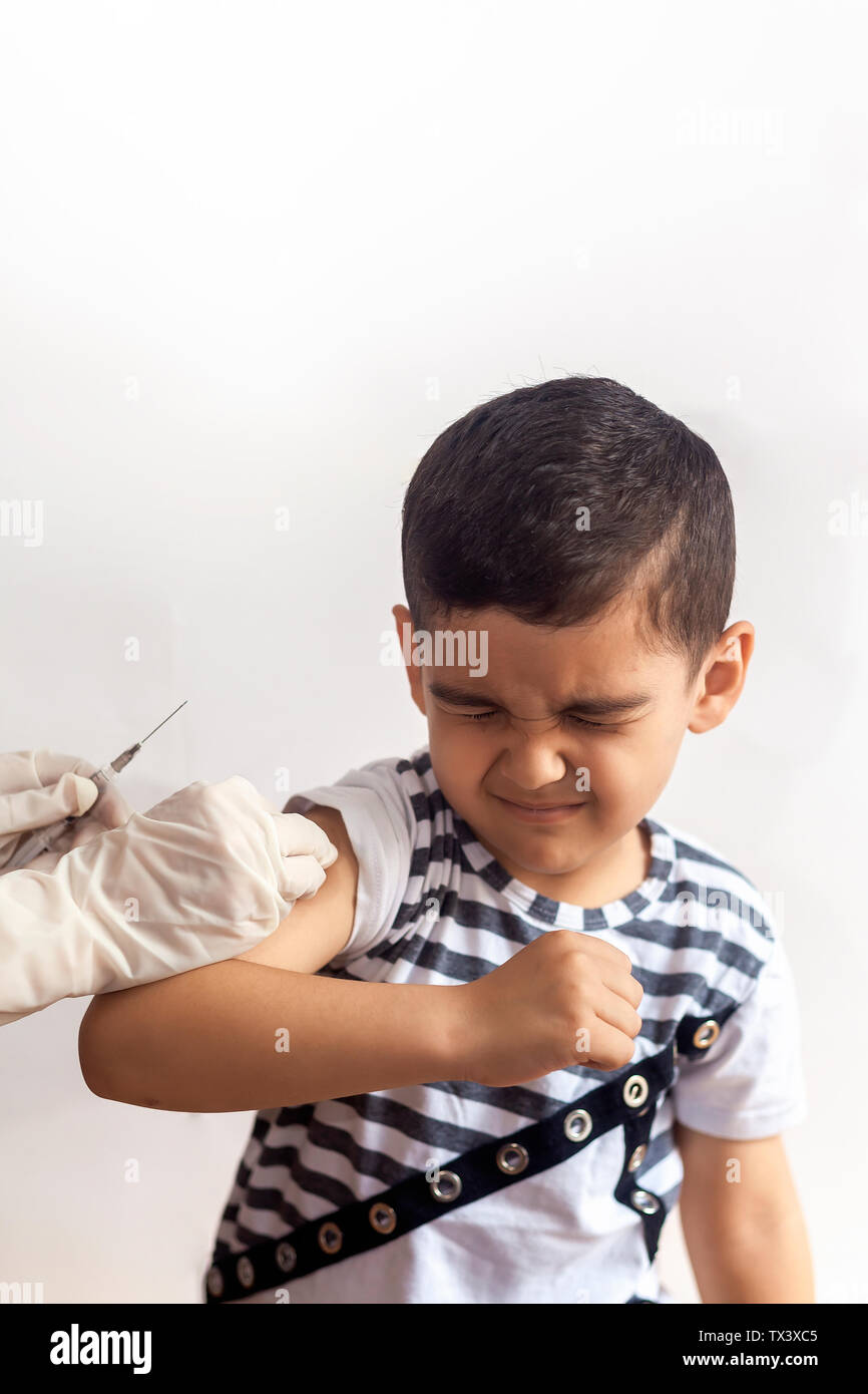 A doctor vaccinating young patient. Little boy scared of injection ...