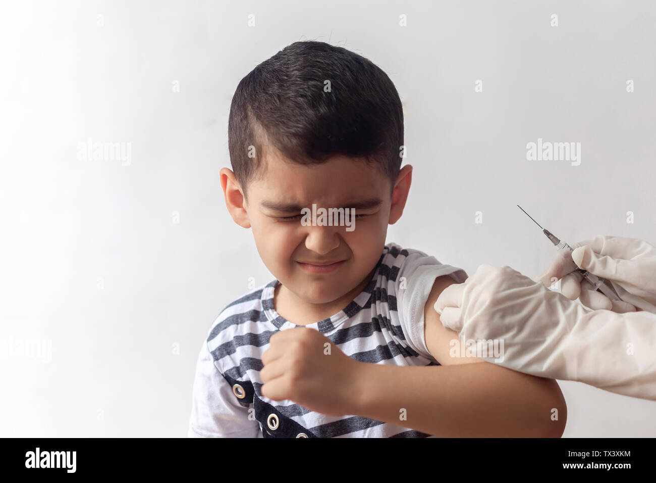 A doctor vaccinating young patient. Little boy scared of injection ...