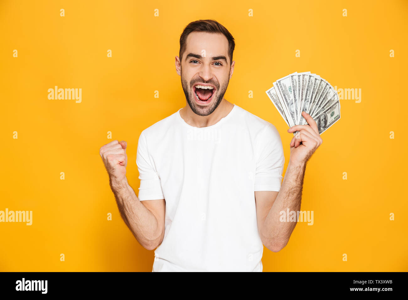 Portrait of a cheerful young man standing isolated over yellow ...