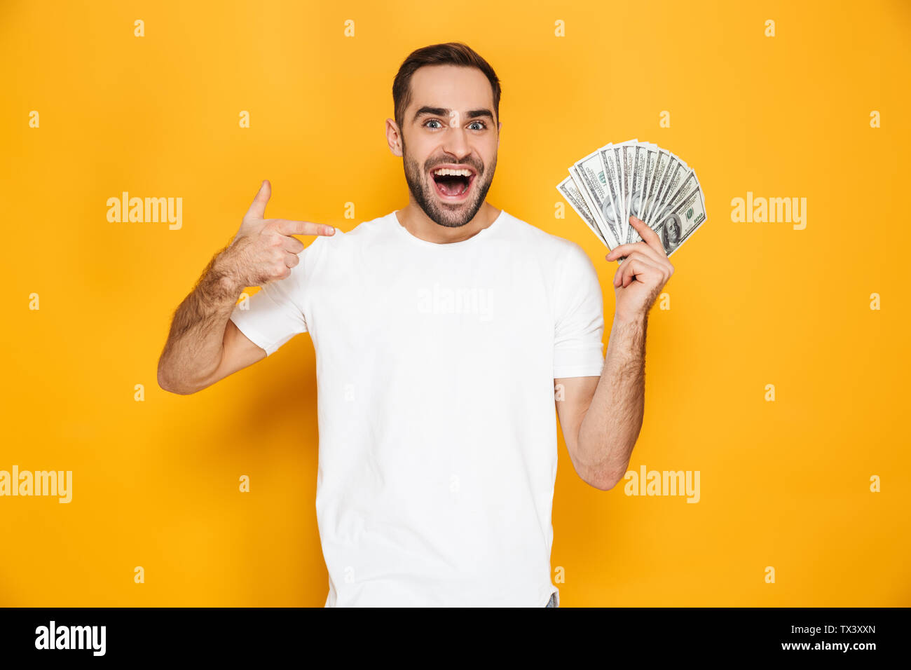 Portrait of a cheerful young man standing isolated over yellow ...